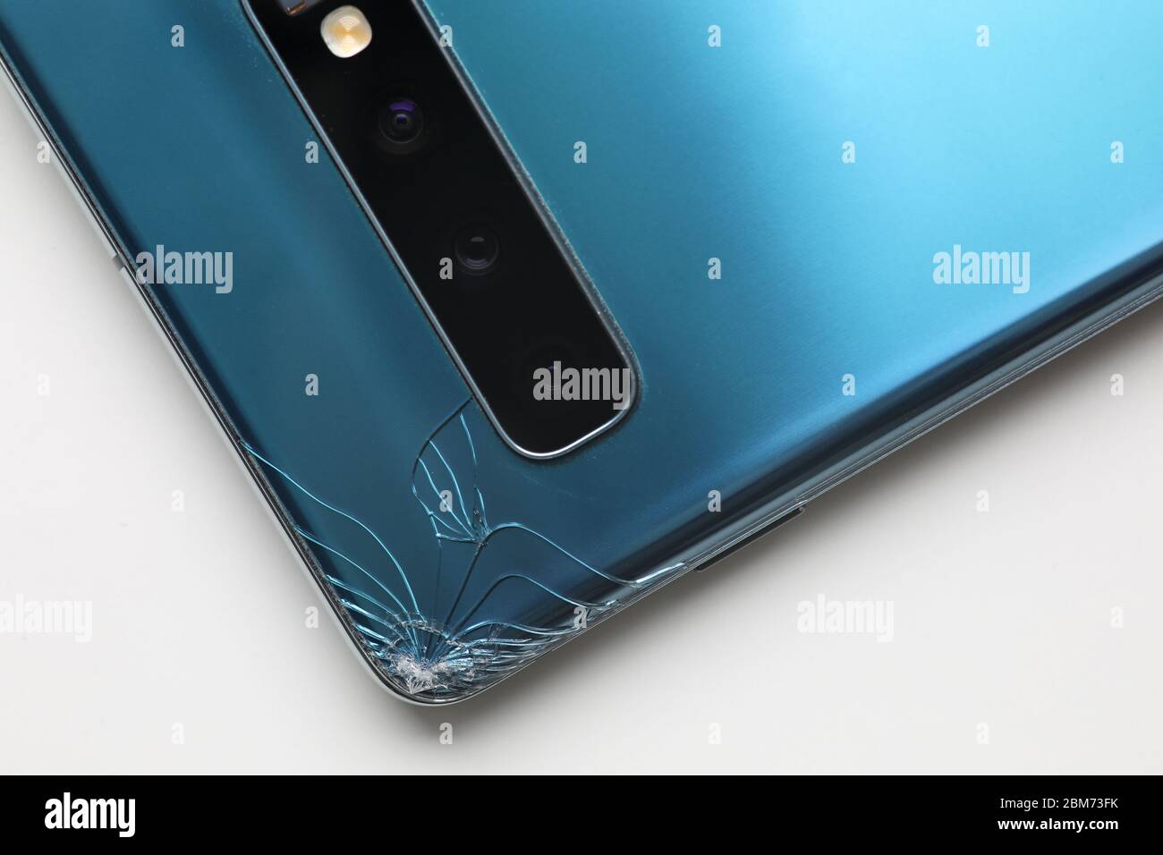 Modern smartphone lying at table with crack in corner Stock Photo - Alamy
