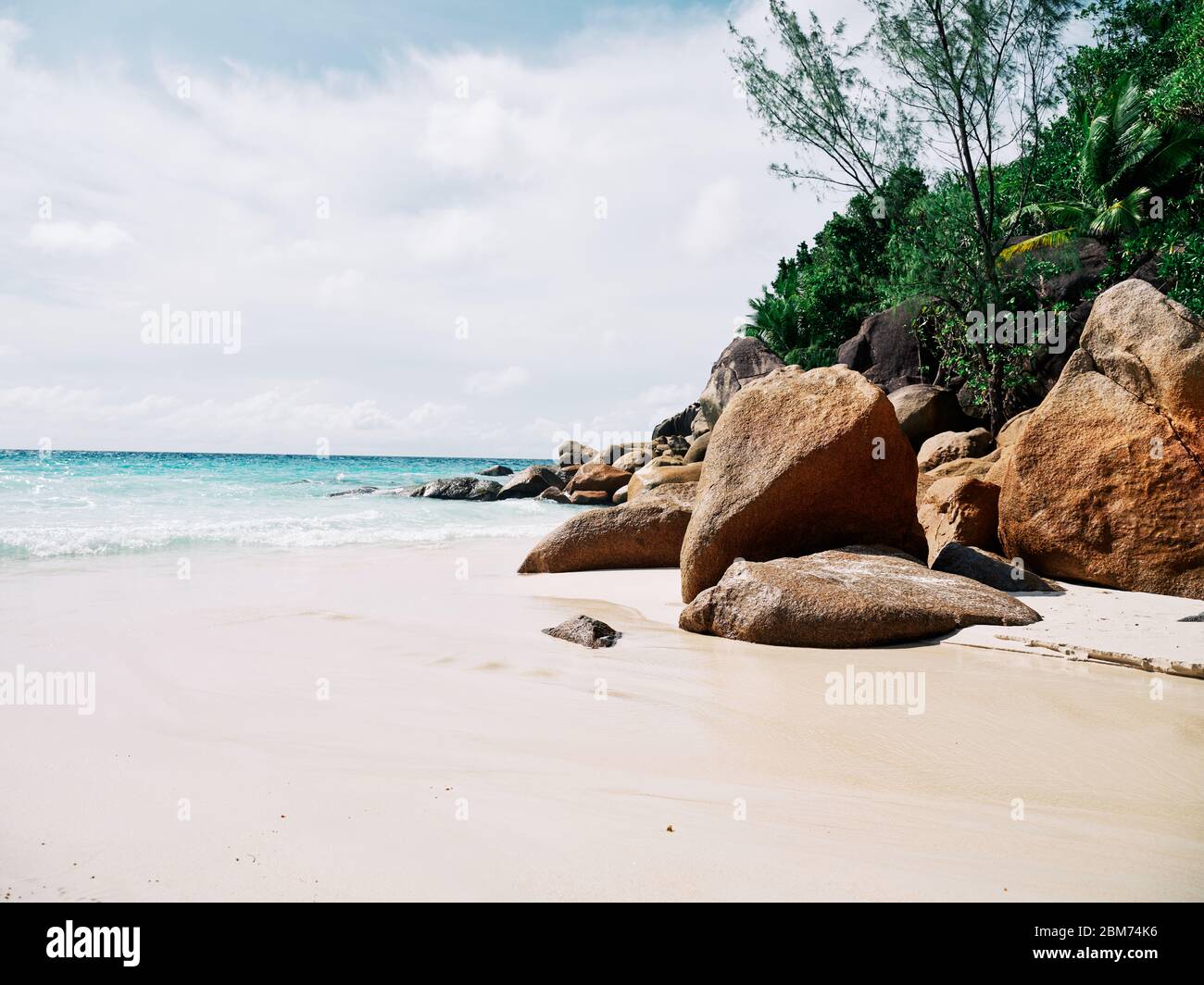 Tropical beach with rocks Stock Photo - Alamy