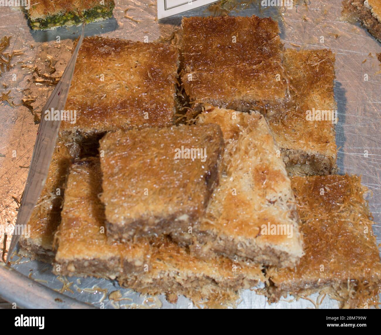 Tray in the showcase with turkish traditional dessert, baklava, cataif ...