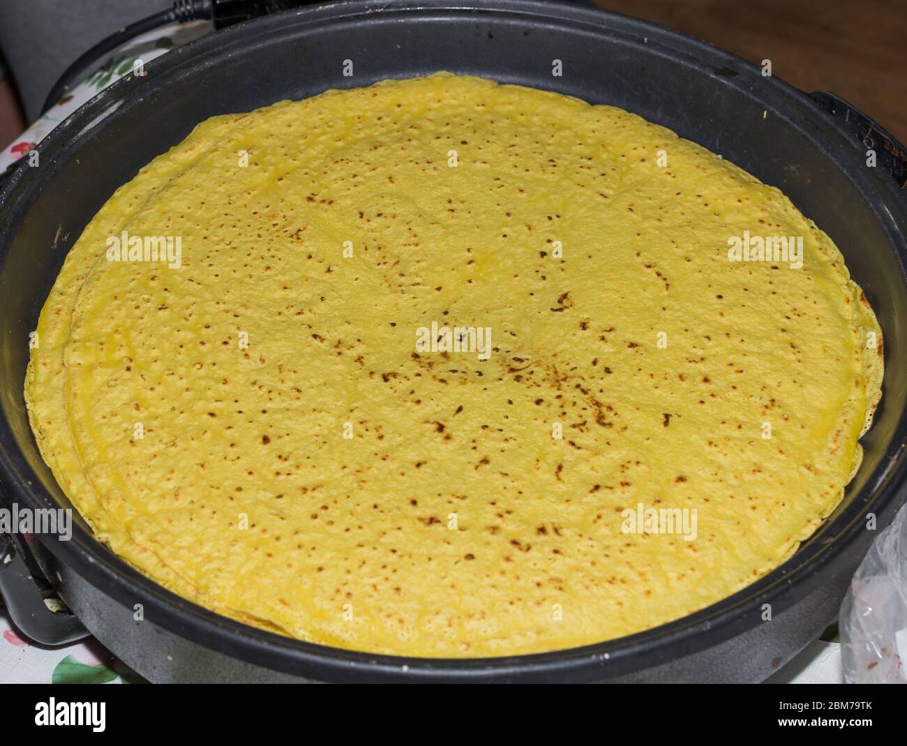 Homemade golden pancake on the pancake station device, during street ...