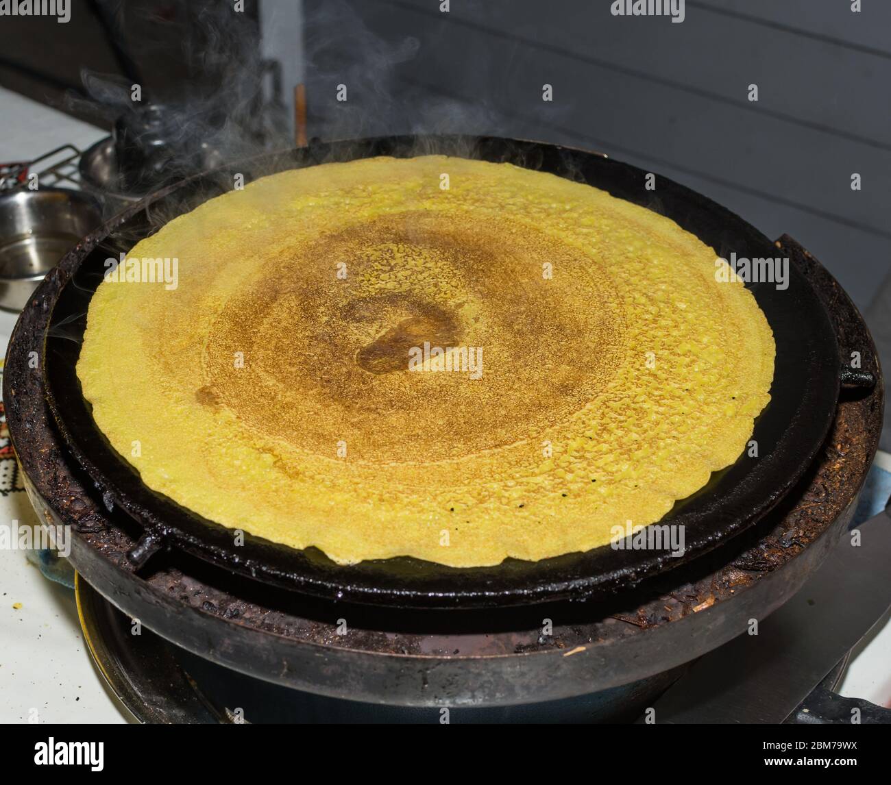 Homemade golden pancake on the pancake station device, during street ...