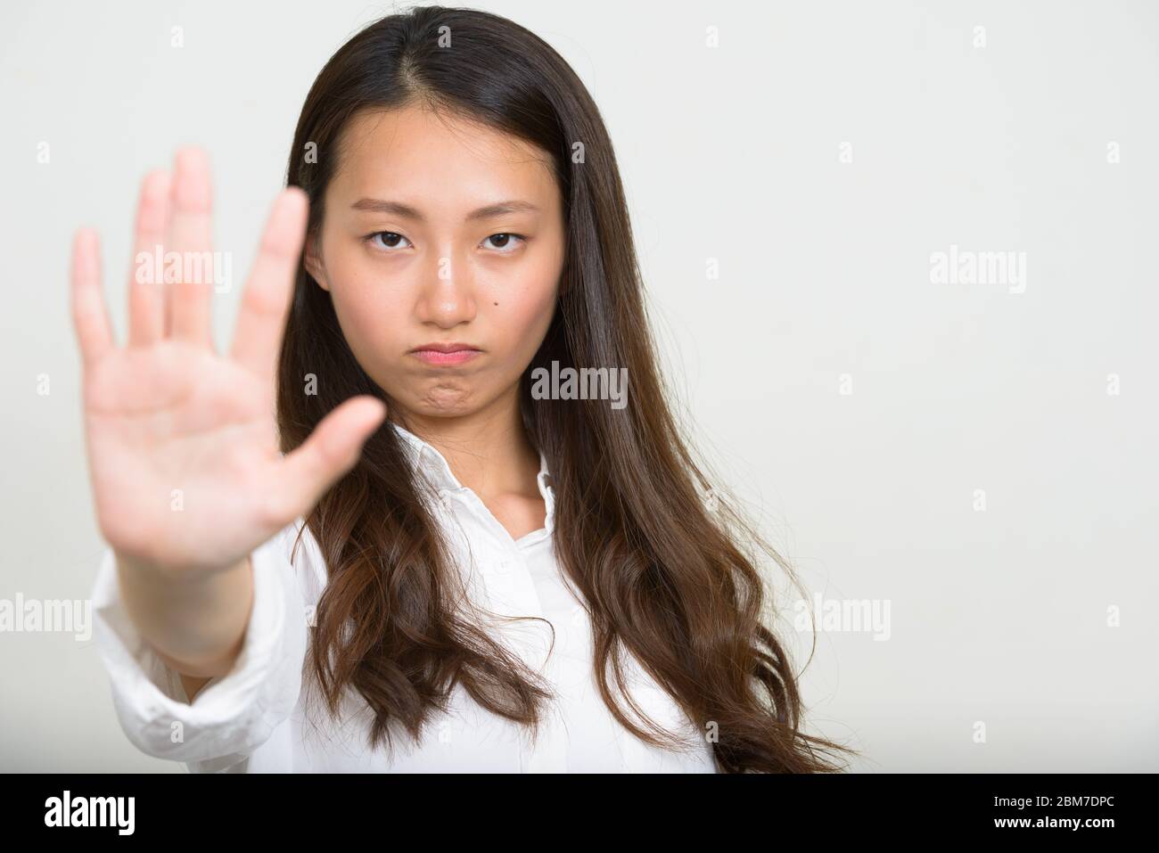 Stressed young Asian businesswoman showing stop gesture Stock Photo - Alamy