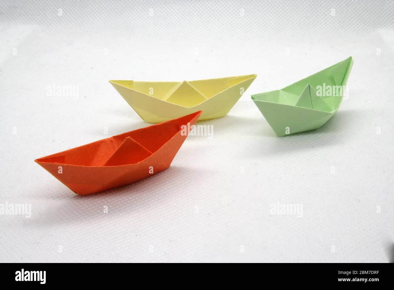 Colorful paper boats. Paper boats in a various colors on a white ...