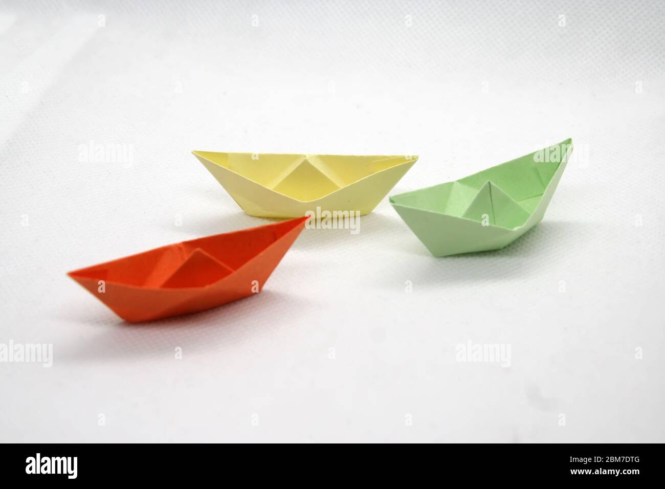 Colorful paper boats. Paper boats in a various colors on a white ...