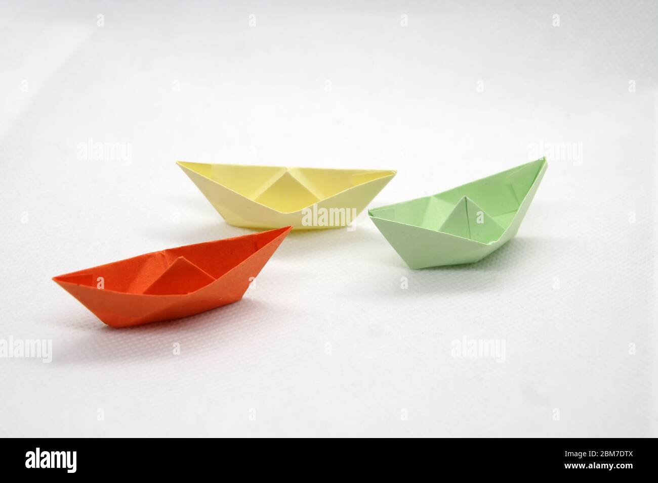 Colorful paper boats. Paper boats in a various colors on a white ...