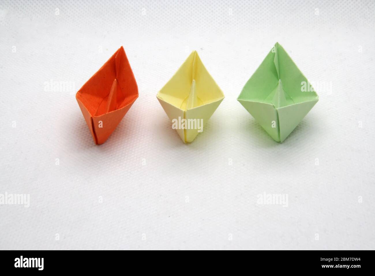 Colorful paper boats. Paper boats in a various colors on a white ...
