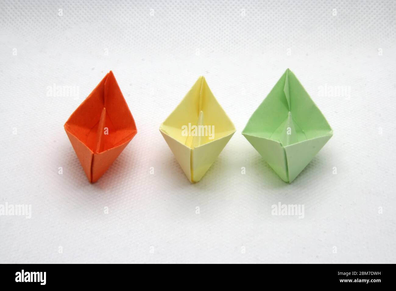 Colorful paper boats. Paper boats in a various colors on a white ...