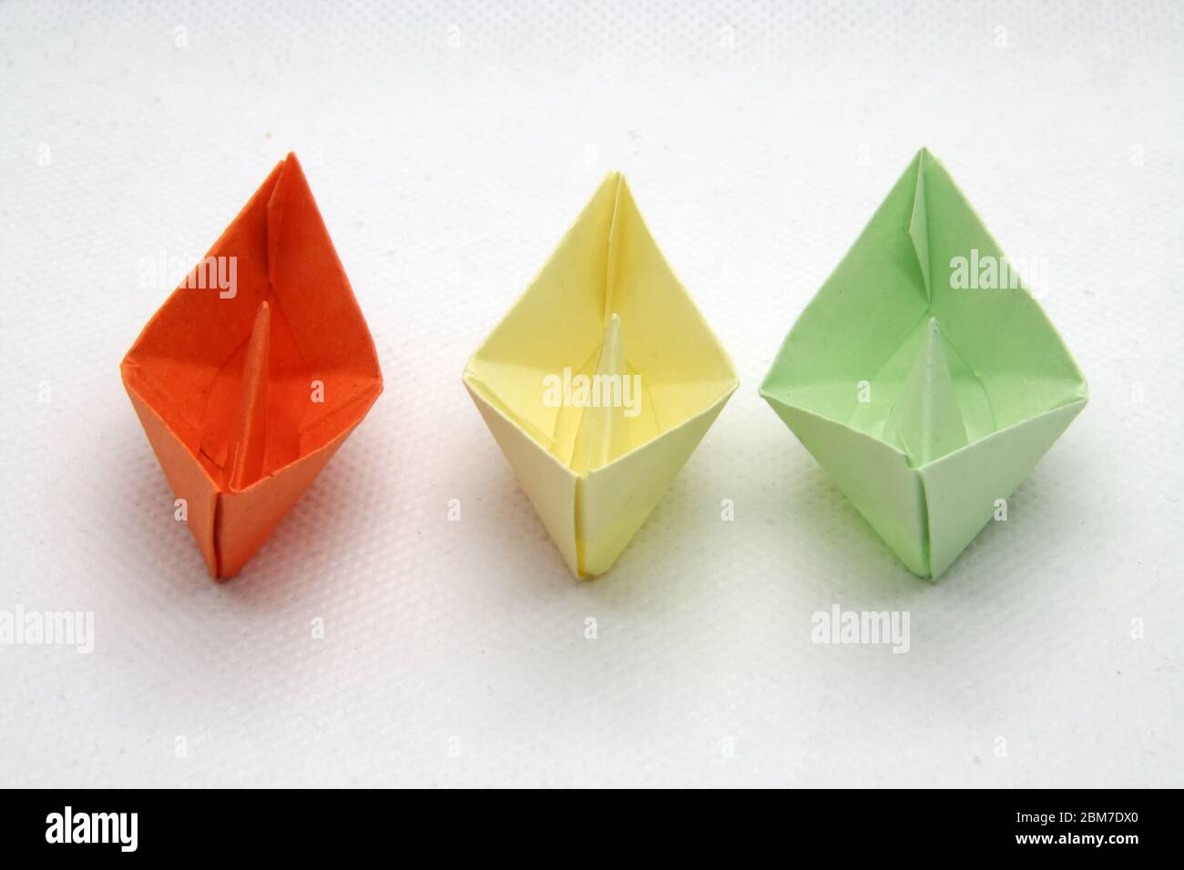 Colorful paper boats. Paper boats in a various colors on a white ...