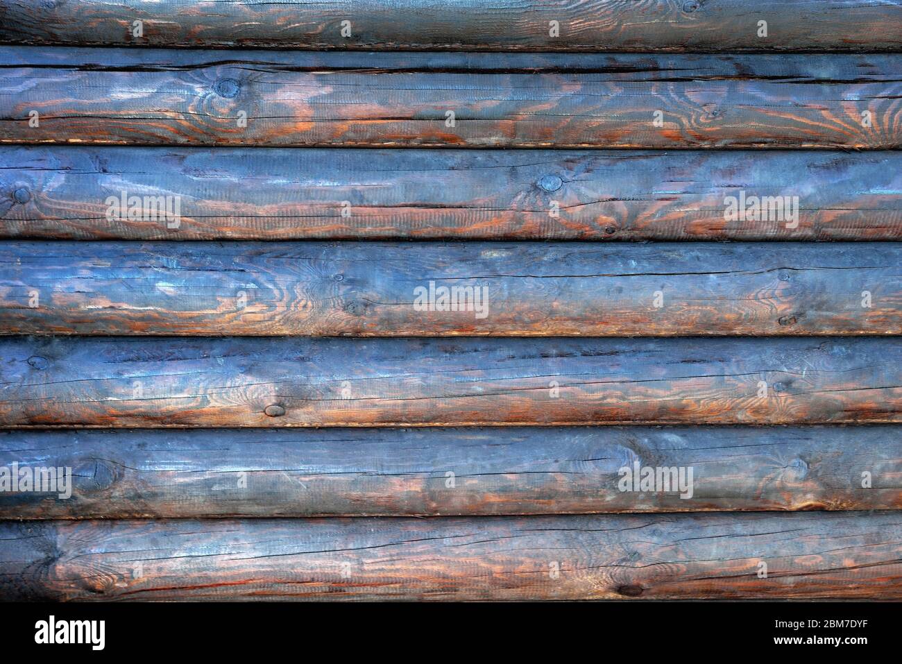 background of wooden natural logs of round brown color with tinted ...