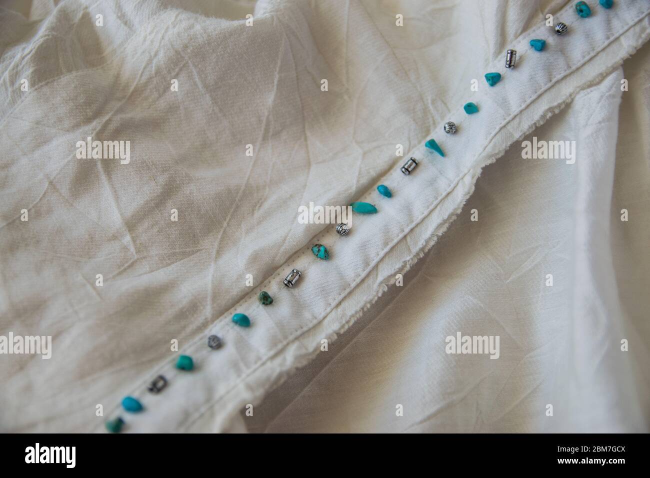 Beige cotton gentle texture clothes with decoration of turquoise ...