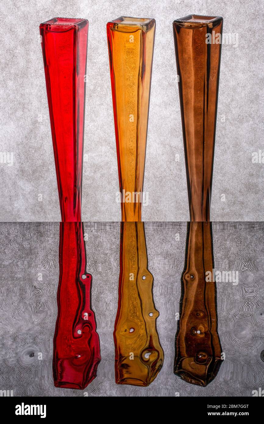 Still life with inverted colored bottles on a reflective surface Stock ...