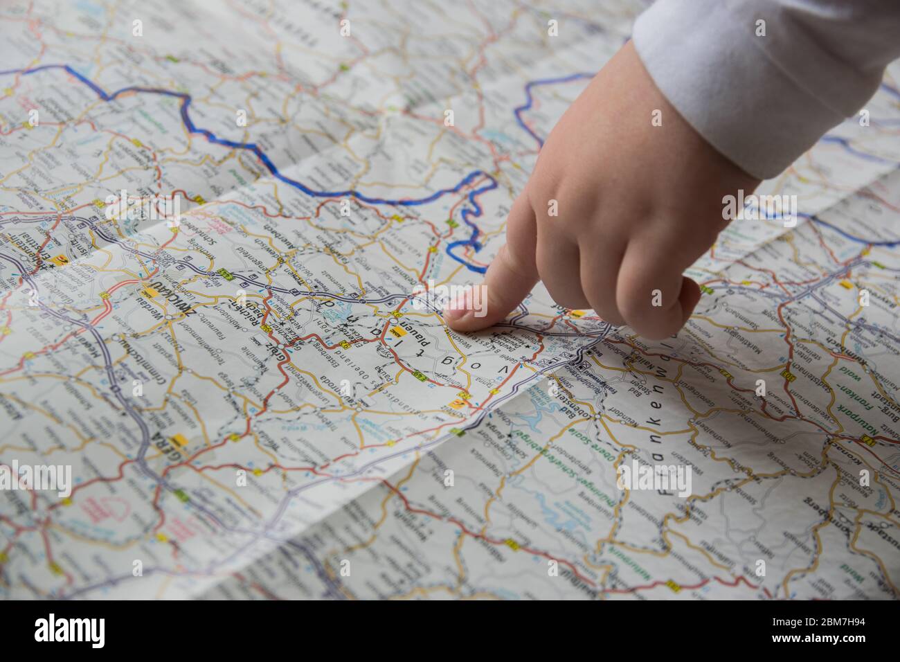 Hand of the child writing on a map with blue pen. Kids hand holding ...