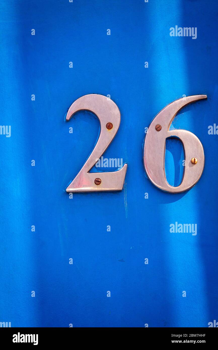 House number 26 in bold, large steel metal digits on a blue wooden ...