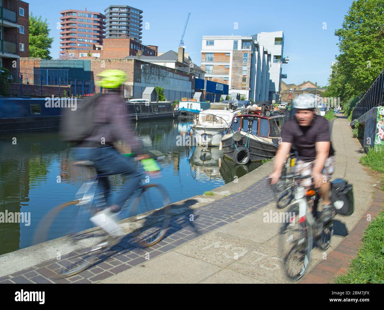 Two commuting cyclists pass by each other on the towpath of the Regent ...