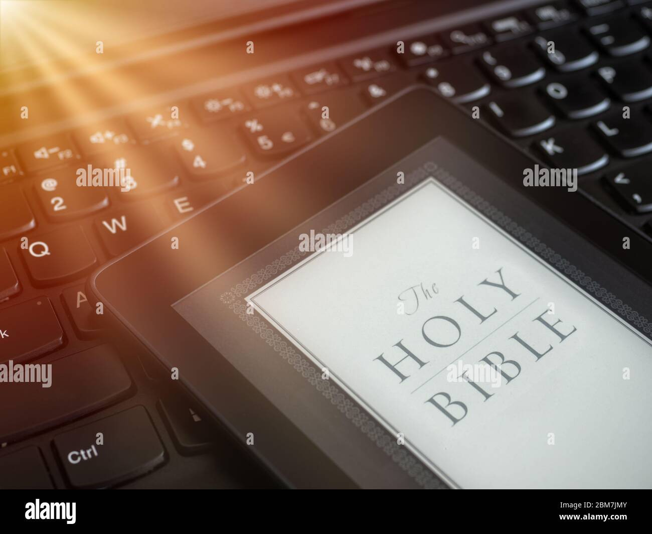 Close up of ebook reader with The Holy Bible on a laptop keyboard, with ...