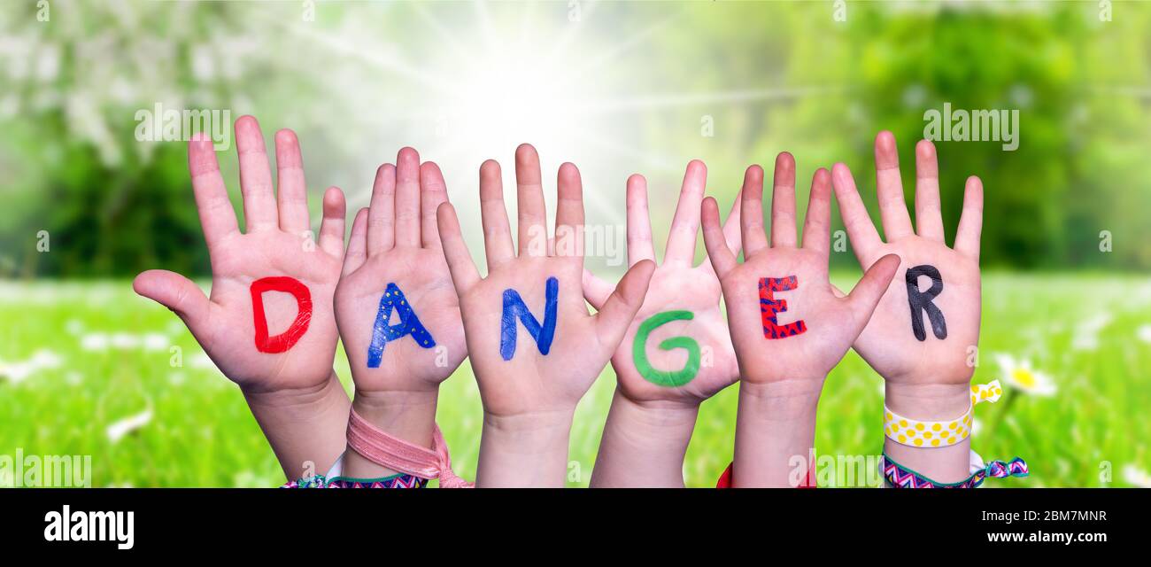 Children Hands Building Word Danger, Grass Meadow Stock Photo - Alamy