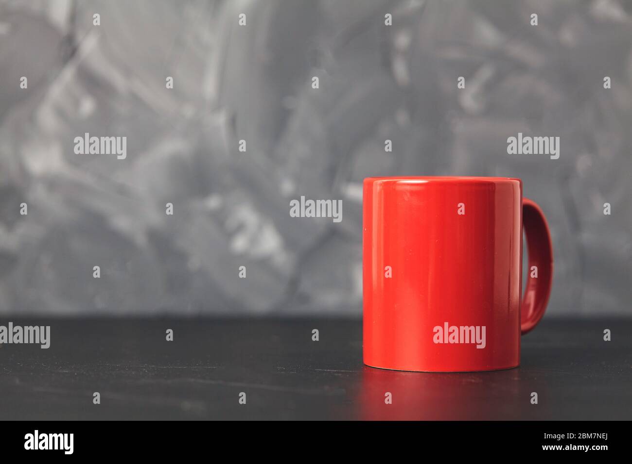 Red cup gray background ron black table. Copy space Stock Photo - Alamy