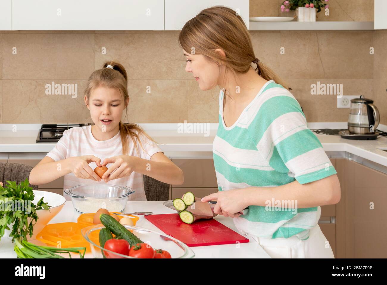 Mother and daughter cook at home. Making cookies, kitchen interior ...
