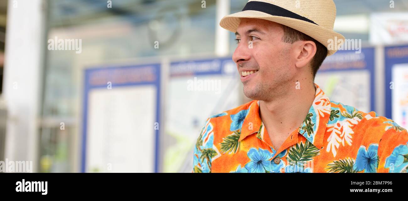Happy young handsome tourist man thinking at the subway station ...