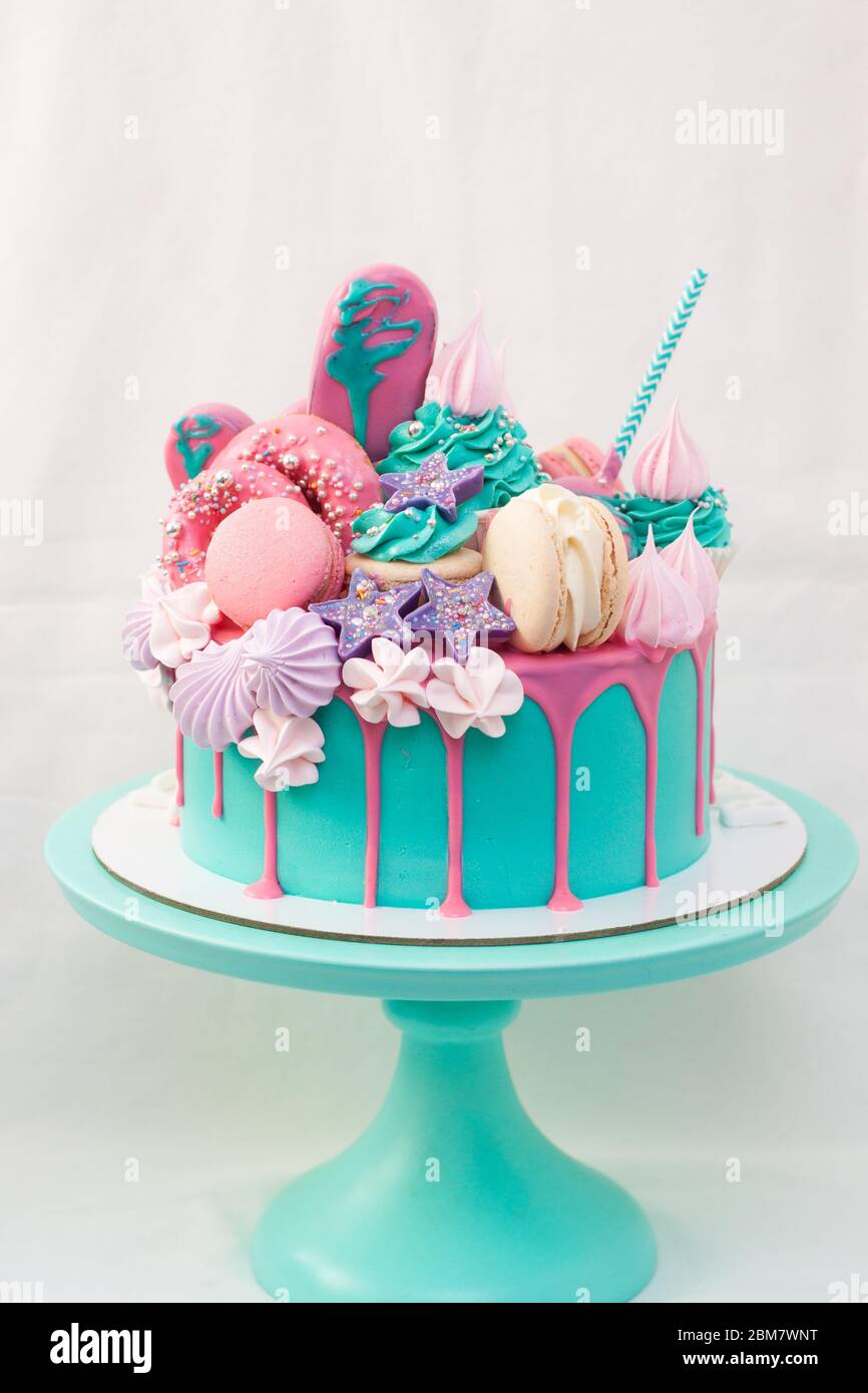 Pink and turquoise cake decorated with macaroons, cupcakes, cake pops ...
