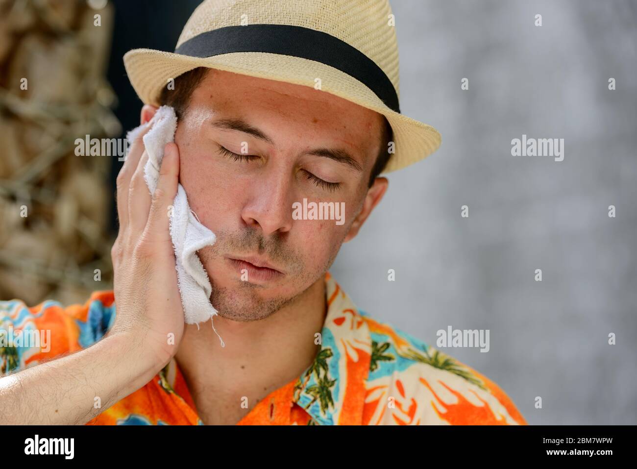 Stressed young tourist man wiping sweat in the city outdoors Stock ...