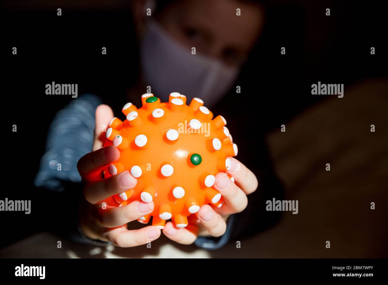 Red bright spiny ball isolated on dark background. Toy, close-up ...