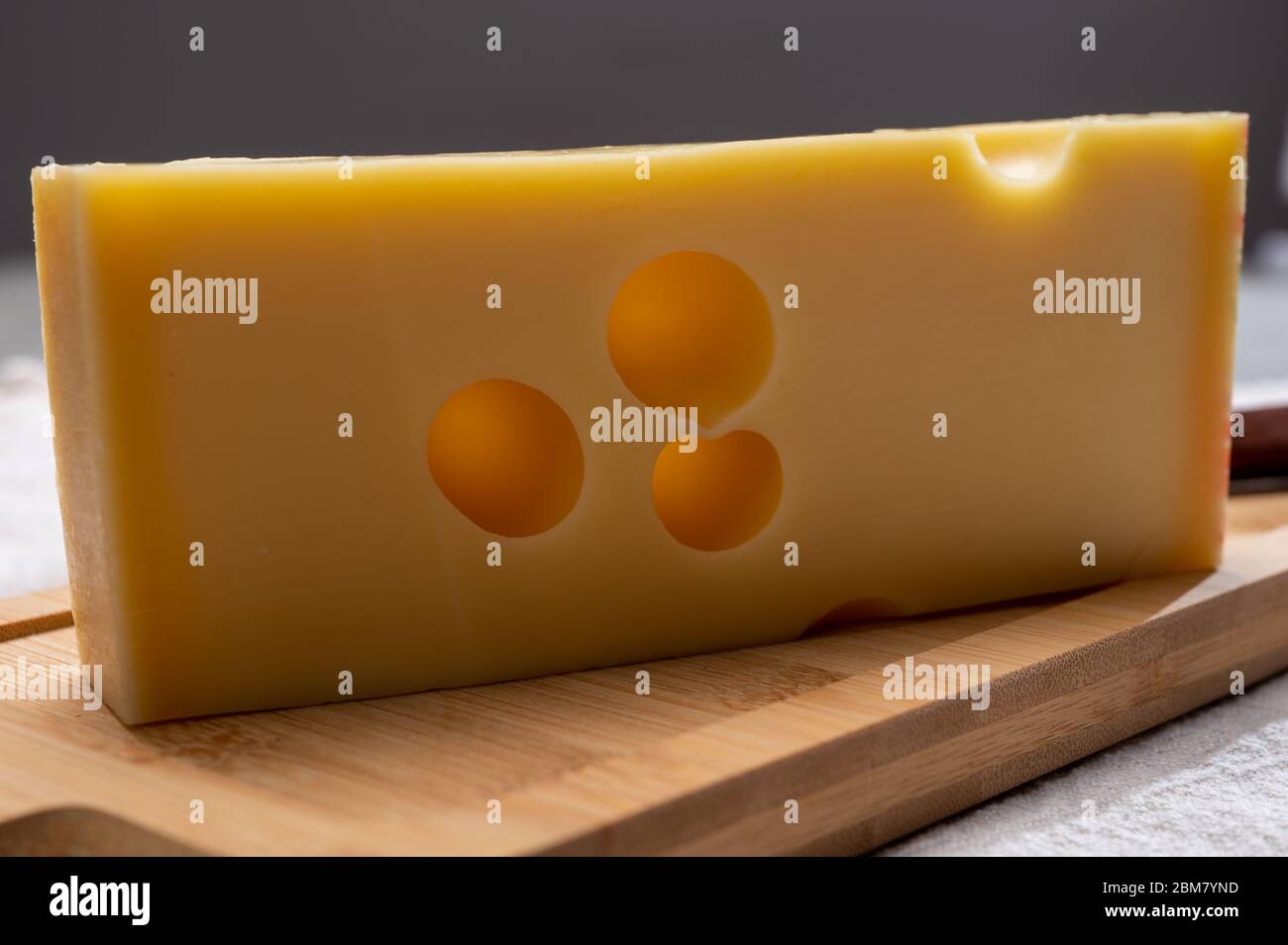 Block of Swiss medium-hard yellow cheese emmental or emmentaler with ...