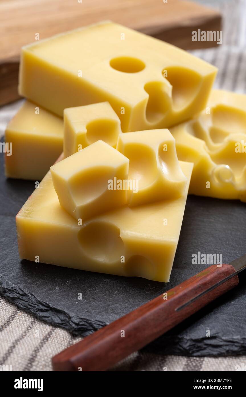 Block of Swiss medium-hard yellow cheese emmental or emmentaler with ...