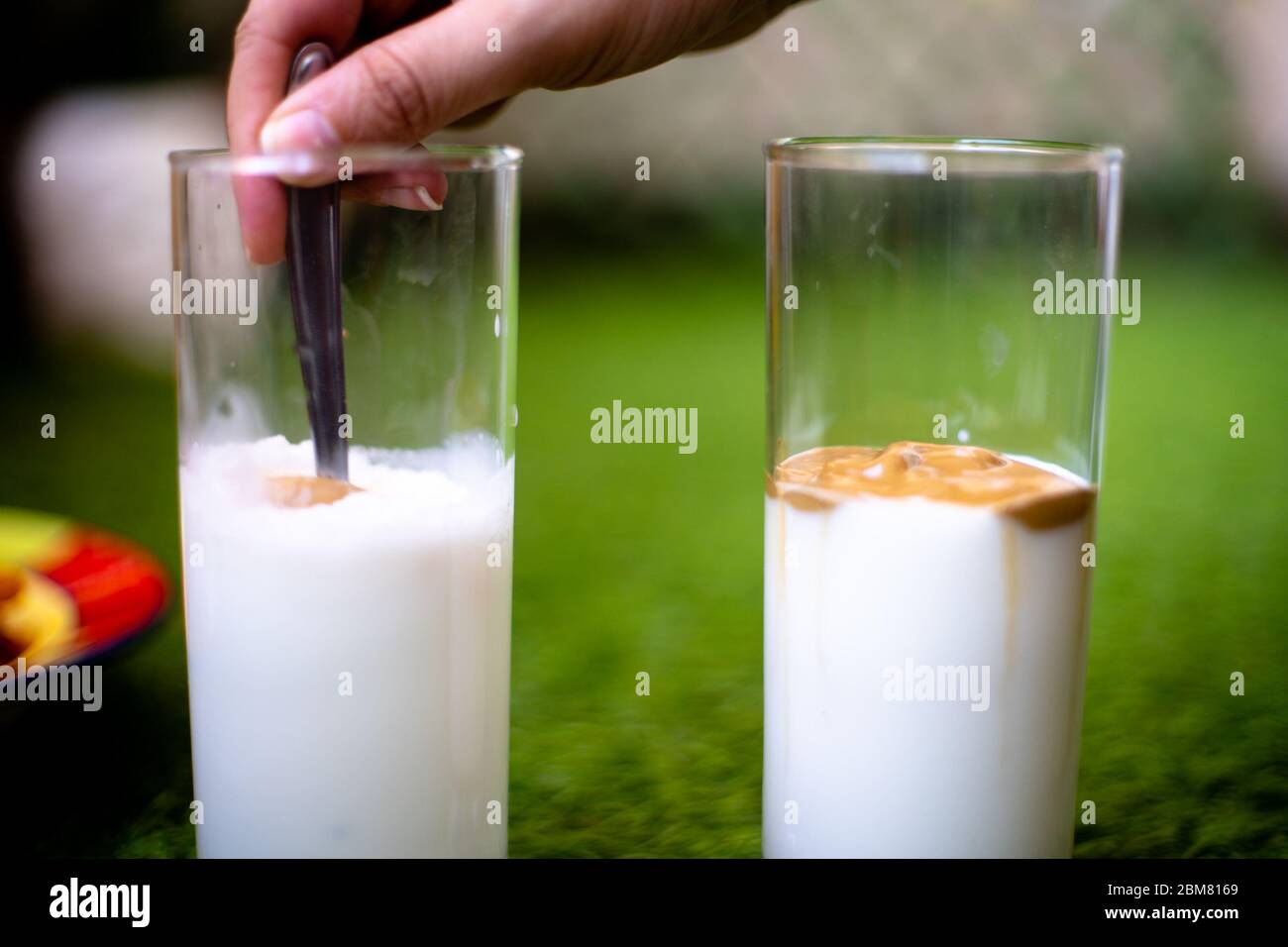 Stirring to mix whipped coffee into thick frothy milk cream to make ...