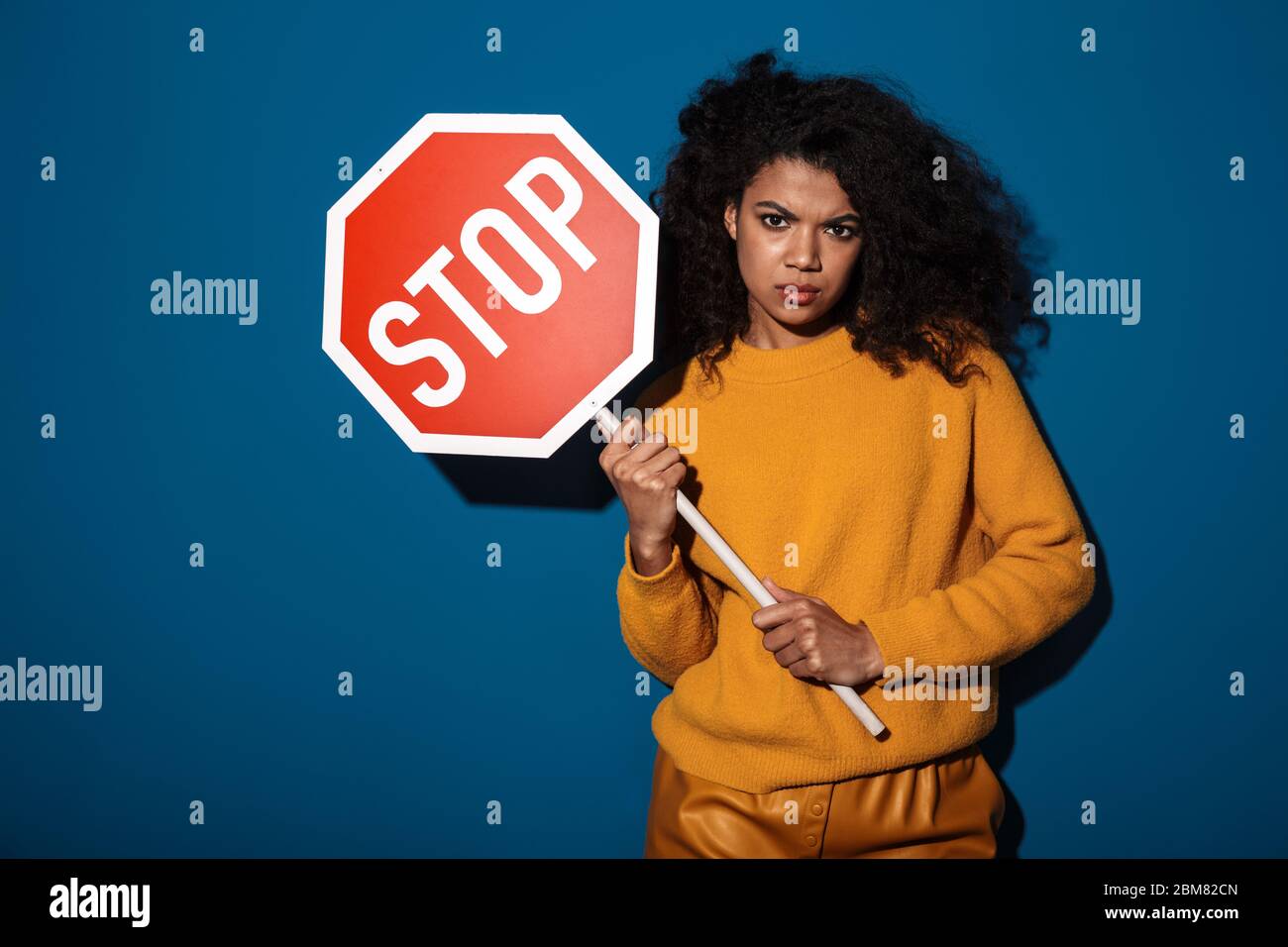Photo of displeased angry young african woman posing isolated over blue ...