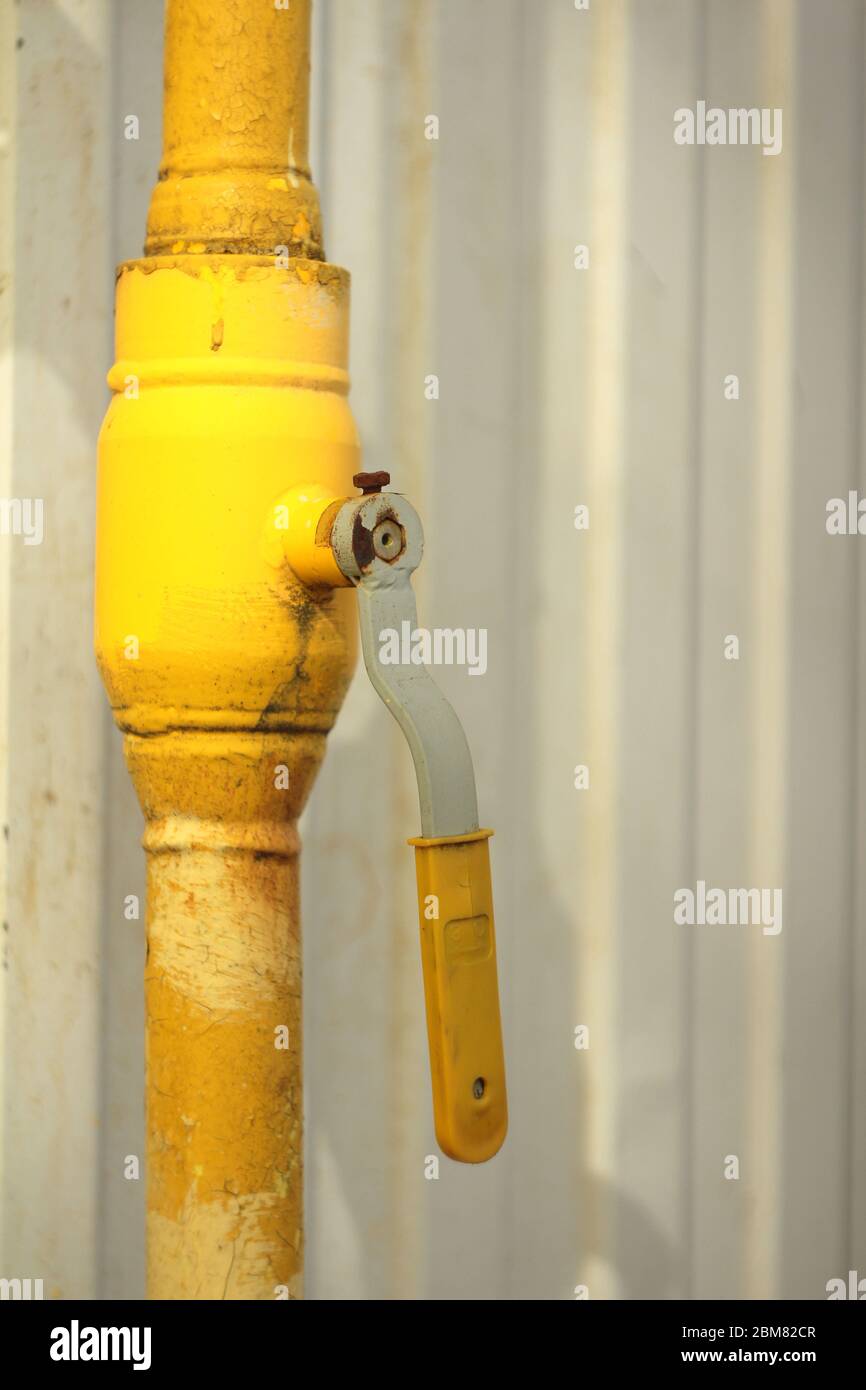 A yellow gas pipe with a valve, a valve with a handle in Russia against ...