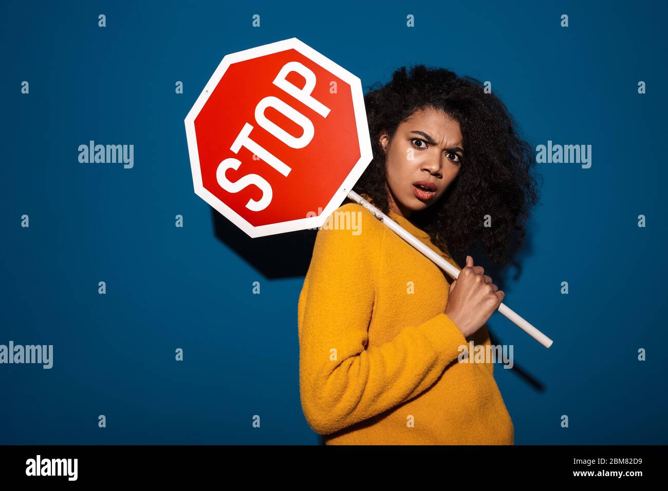 Image of a pretty displeased african woman posing isolated over blue ...