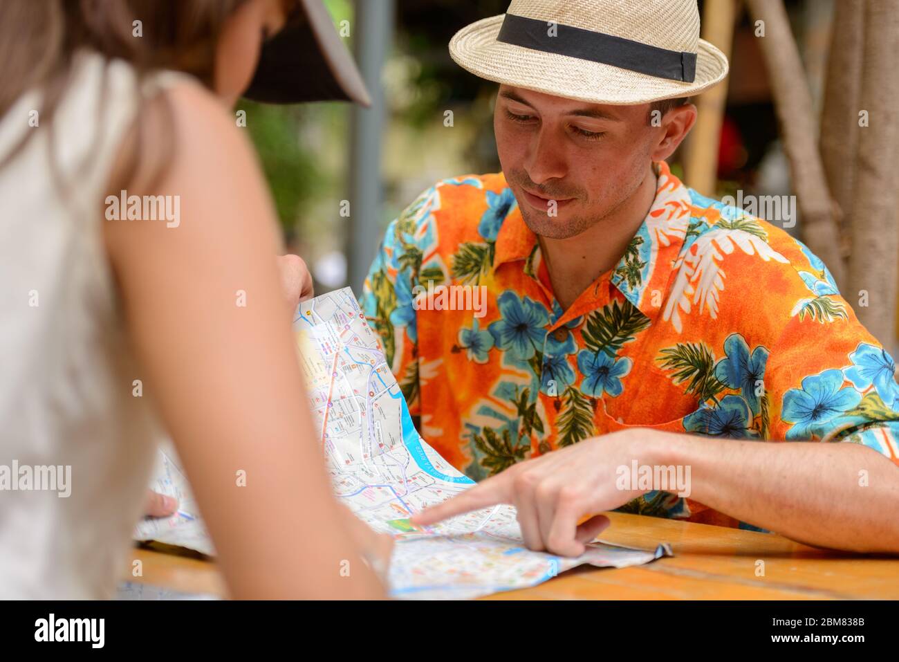 Multi ethnic tourist couple checking map together at restaurant Stock ...