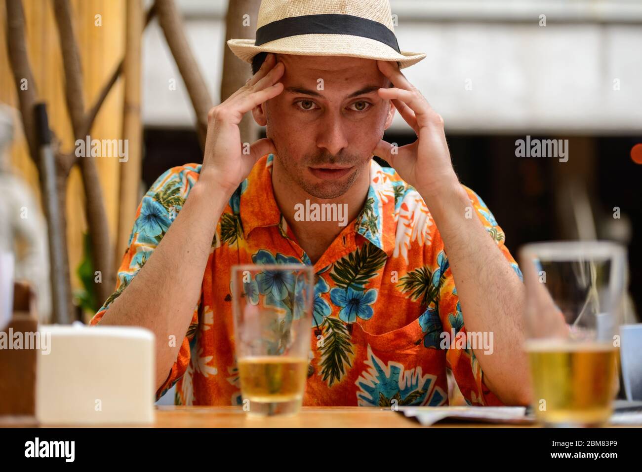 Stressed young tourist man having headache at the restaurant Stock ...