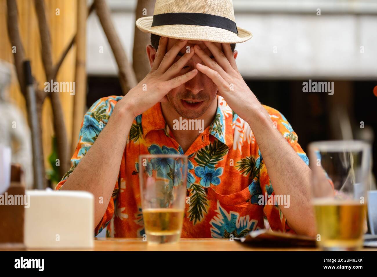 Stressed young tourist man having headache at the restaurant Stock ...
