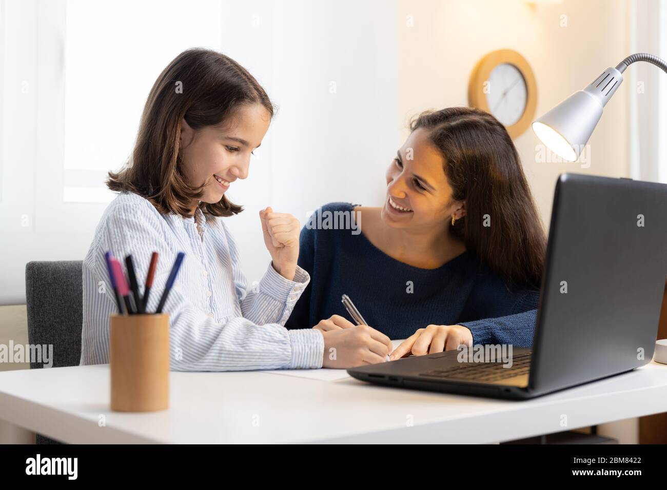 Teen girl giving private lessons to a girl who celebrates success Stock ...