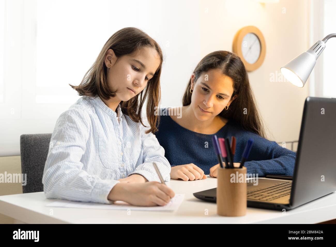 Little girl doing homework with her older sister at home Stock Photo ...