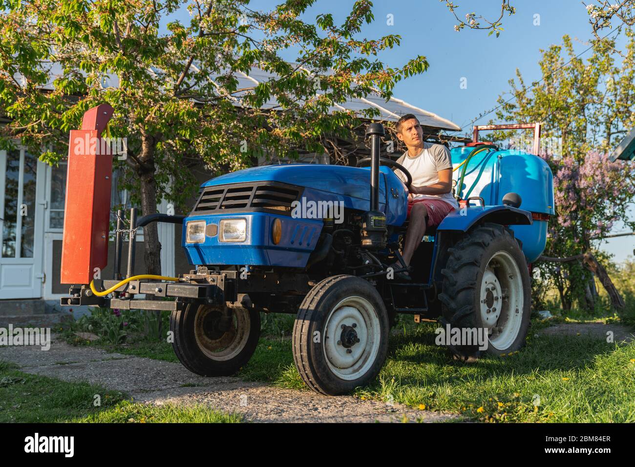 Farmer driving tractor, sprayer machine, trailed by tractor spray Stock ...
