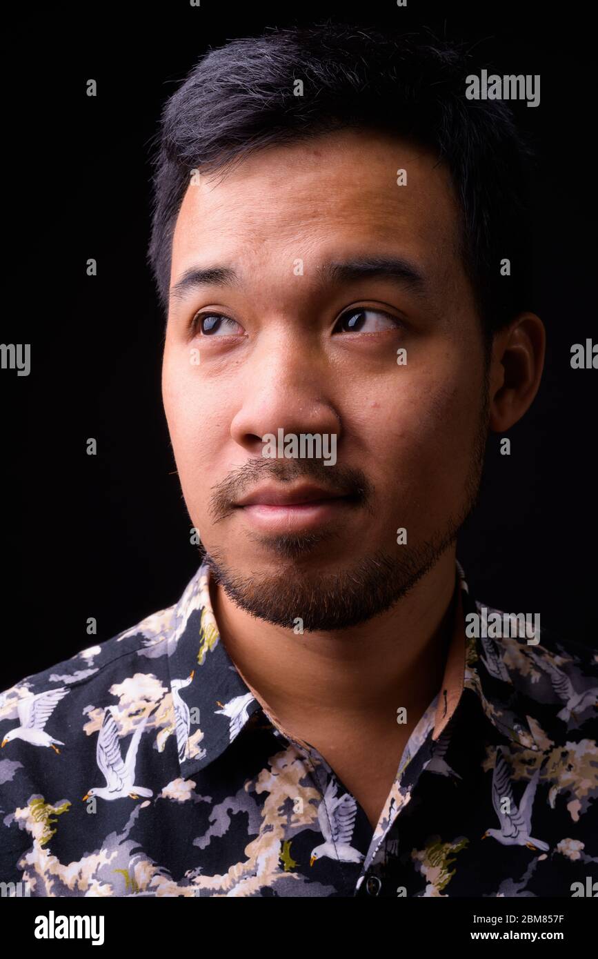 Face of young Asian man thinking and looking up Stock Photo - Alamy