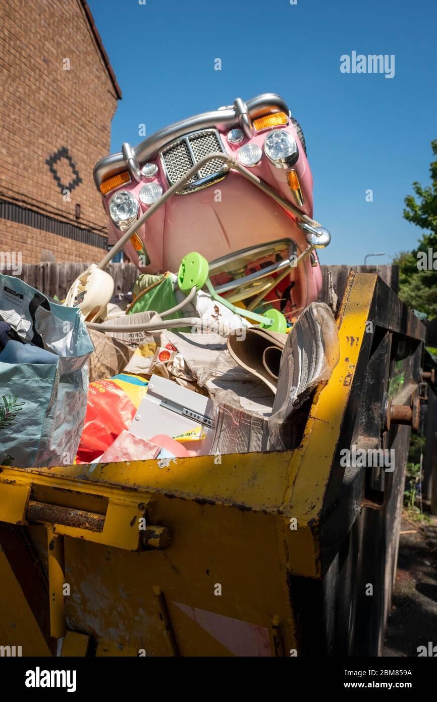 Childs pedal car on top of a refuse skip filled with rubbish Stock ...