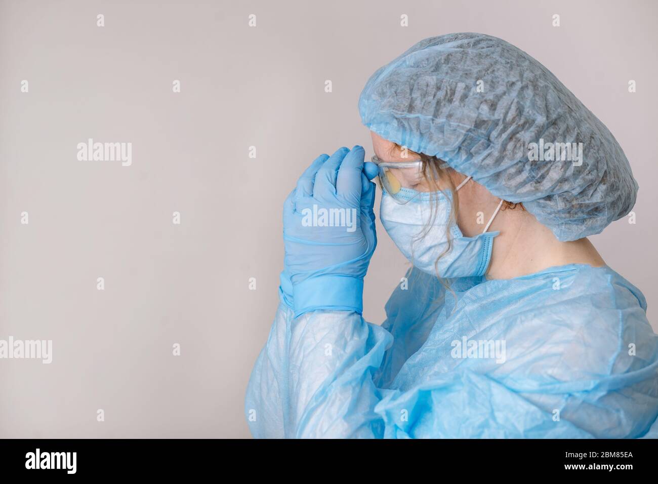 Praying tired doctor. Tired praying nurse at the hospital. The fight ...