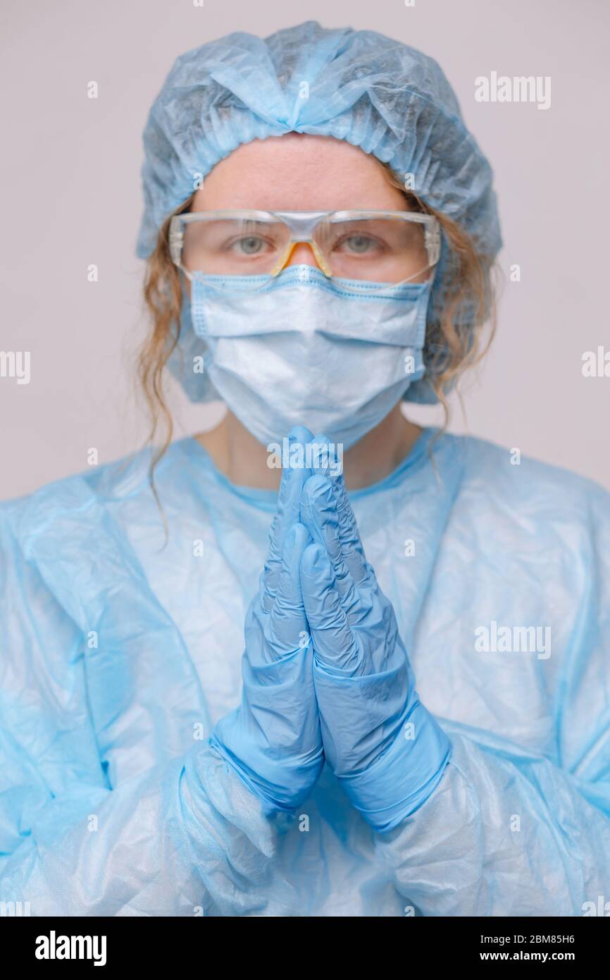 Praying tired doctor. Tired praying nurse at the hospital. The fight ...