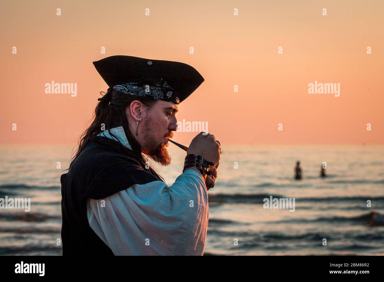 Man dressed up as a pirate smoking a pipe at sunset Stock Photo - Alamy