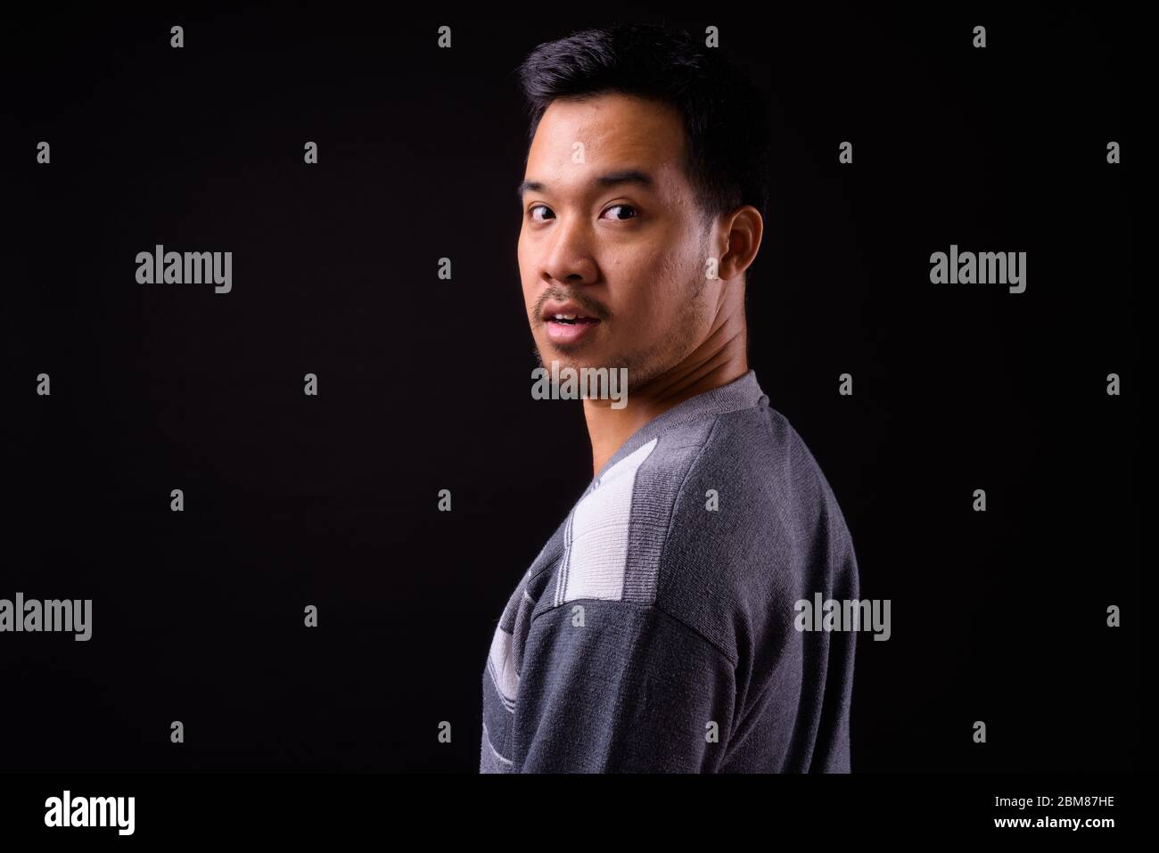 Rear view of young Asian man looking at camera Stock Photo - Alamy