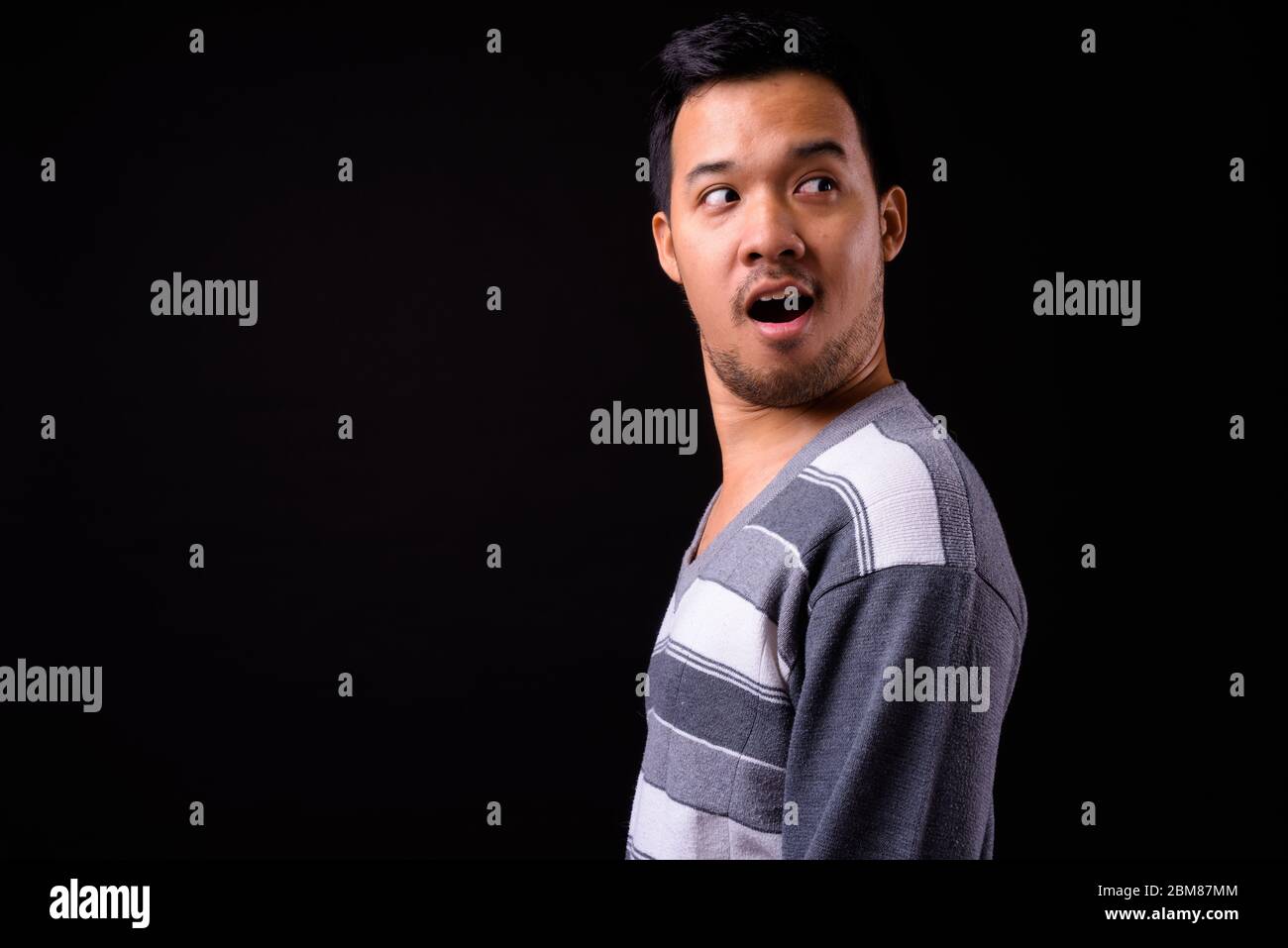 Rear view of shocked young Asian man looking back Stock Photo - Alamy