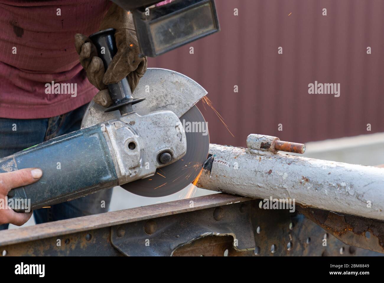 Front view of a sander used to smooth a welding seam on a metal bar ...