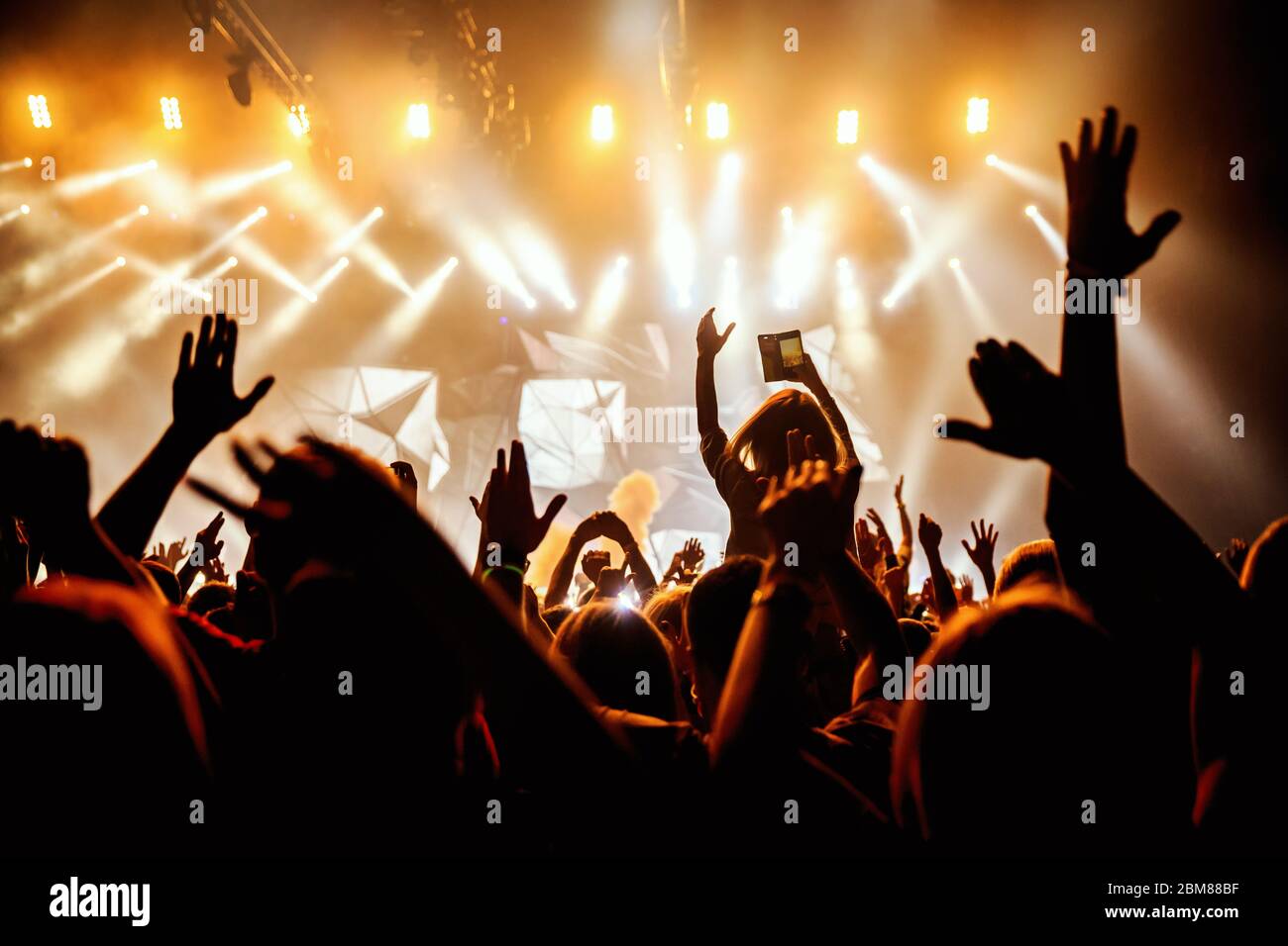 People black silhouettes of rock concert crowd in front of bright stage ...
