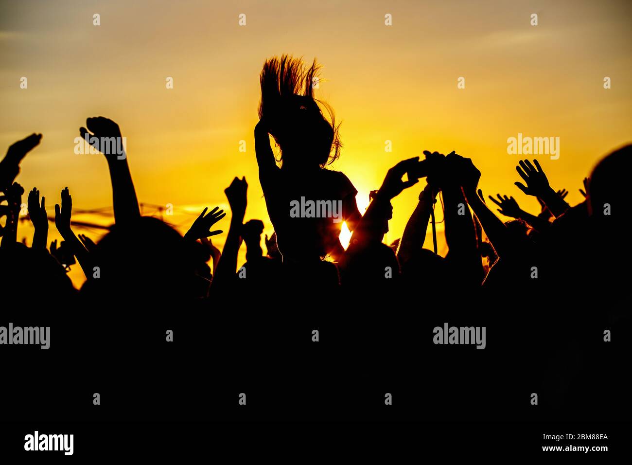 The crowd enjoys the summer music festival, sunset, the silhouettes ...