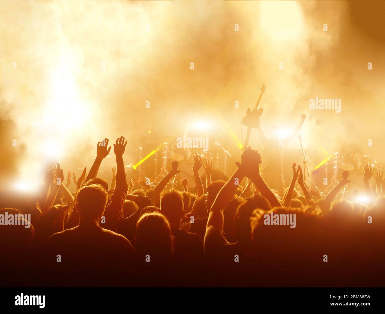 Rock concert, cheering crowd in front of bright colorful stage lights ...