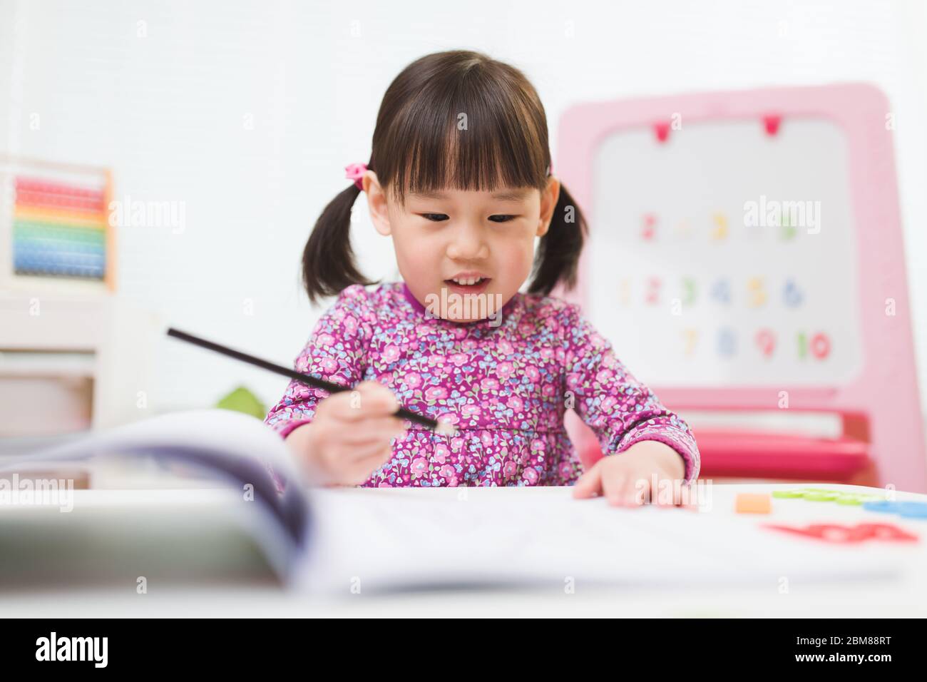 toddler girl practice writing letters for homeschooling Stock Photo - Alamy